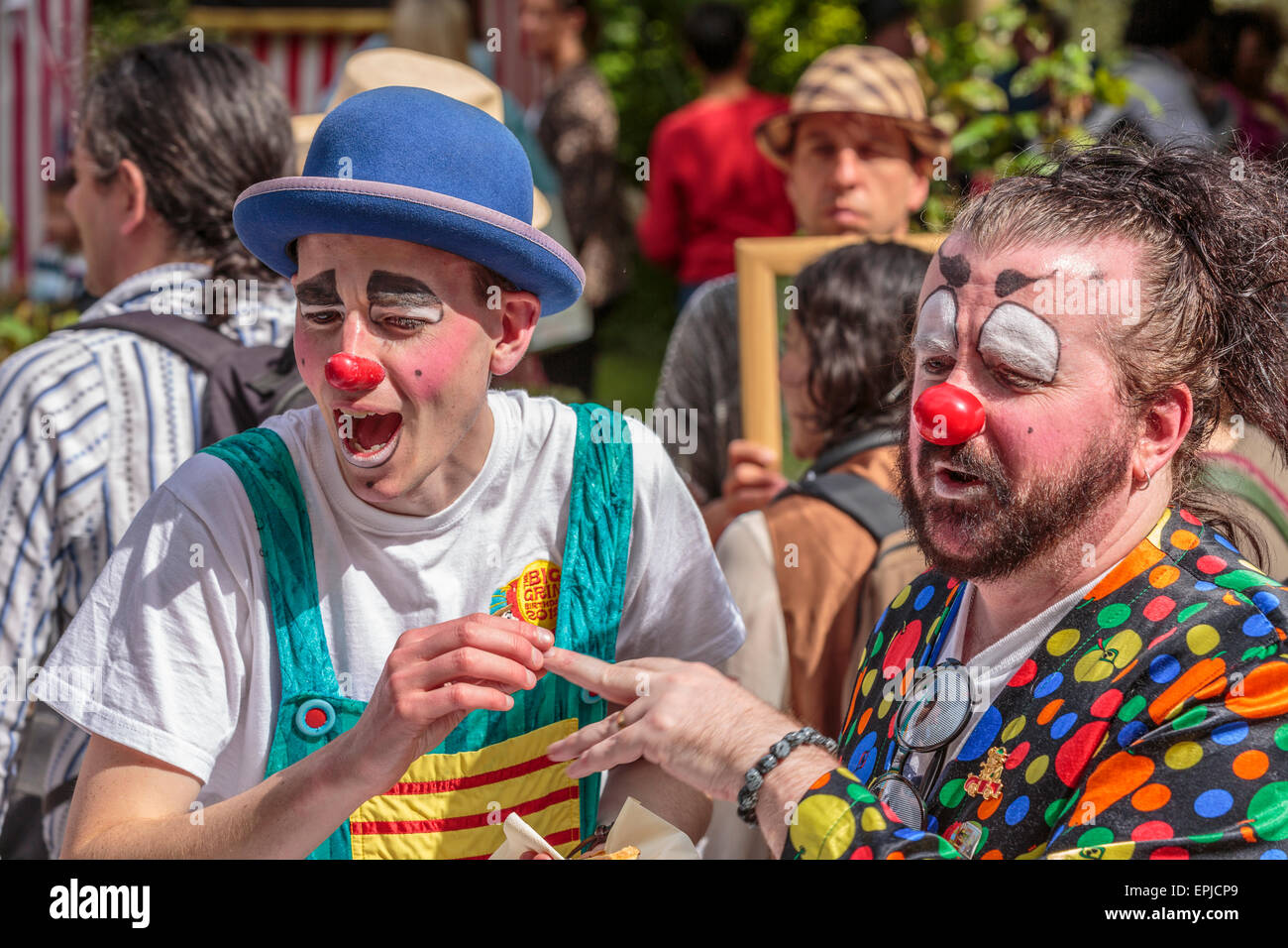 A Portrait of a pair of clowns pretending to put a ring on a finger ...