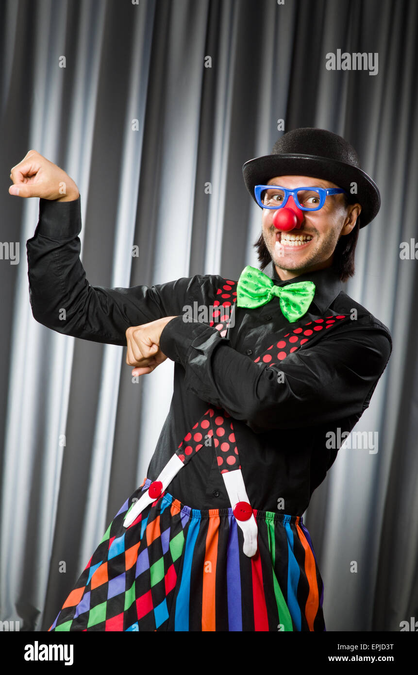 Funny clown in humorous concept against curtain Stock Photo - Alamy