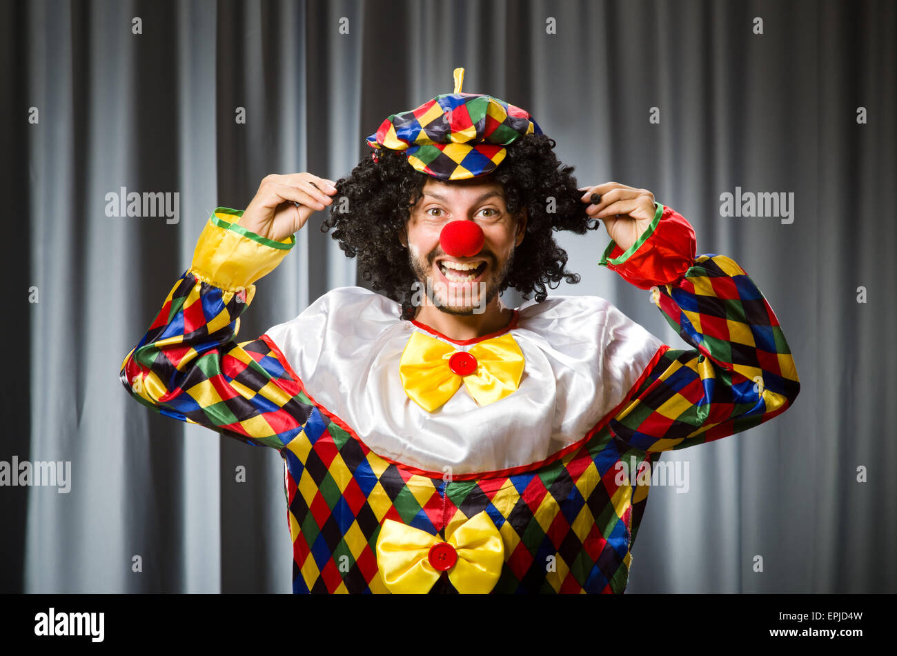 Funny clown in humorous concept against curtain Stock Photo - Alamy
