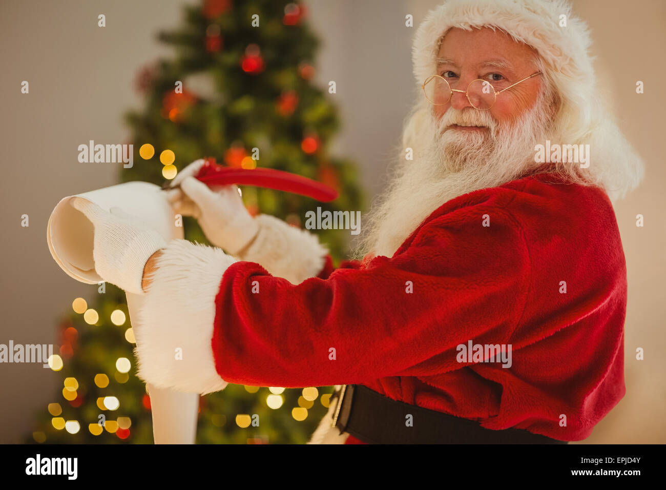 Smiling santa claus writing list Stock Photo - Alamy