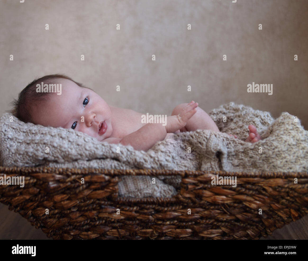 Baby boy in the basket on the wooden floor Stock Photo - Alamy
