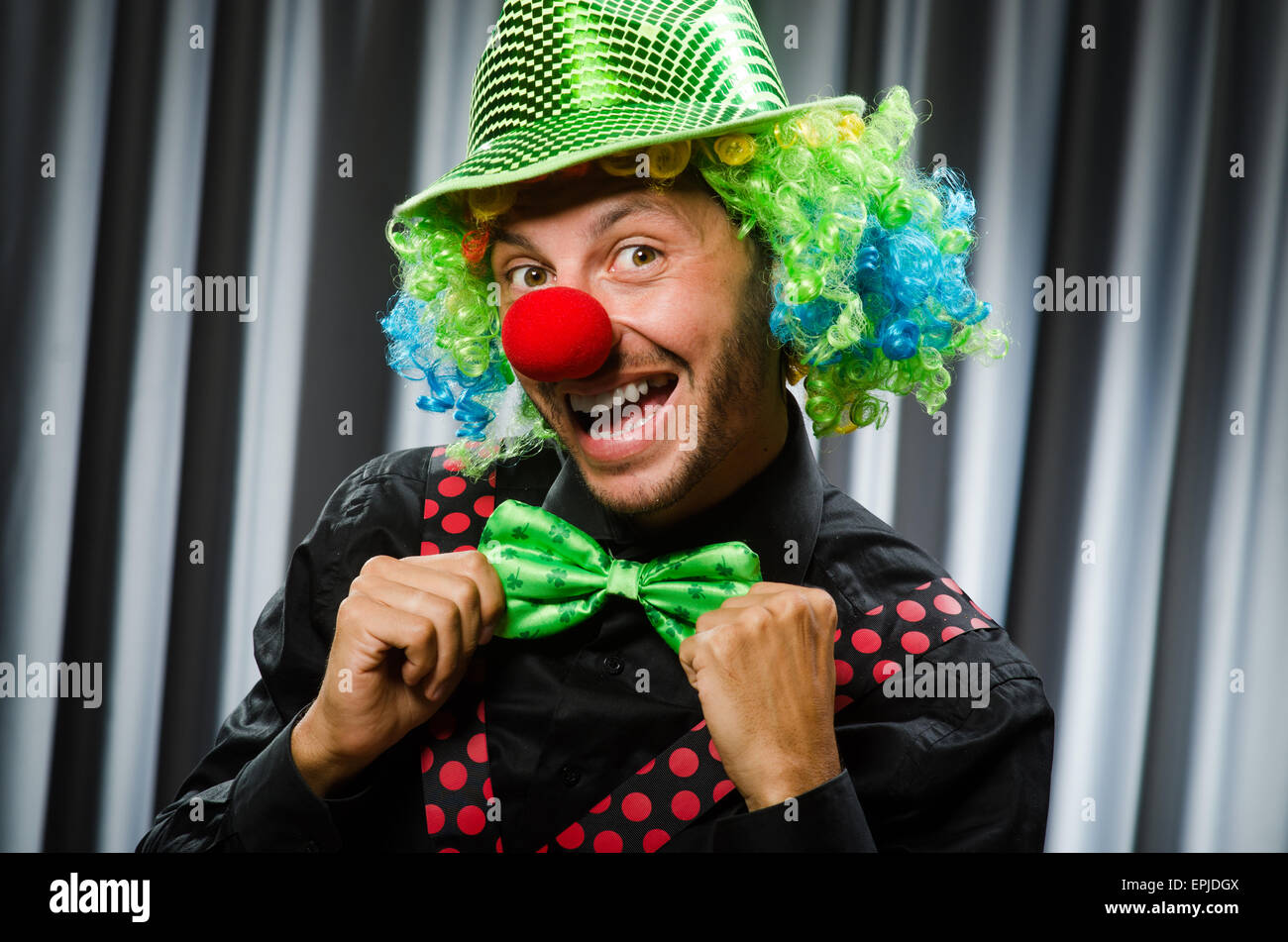 Funny clown in humorous concept against curtain Stock Photo - Alamy
