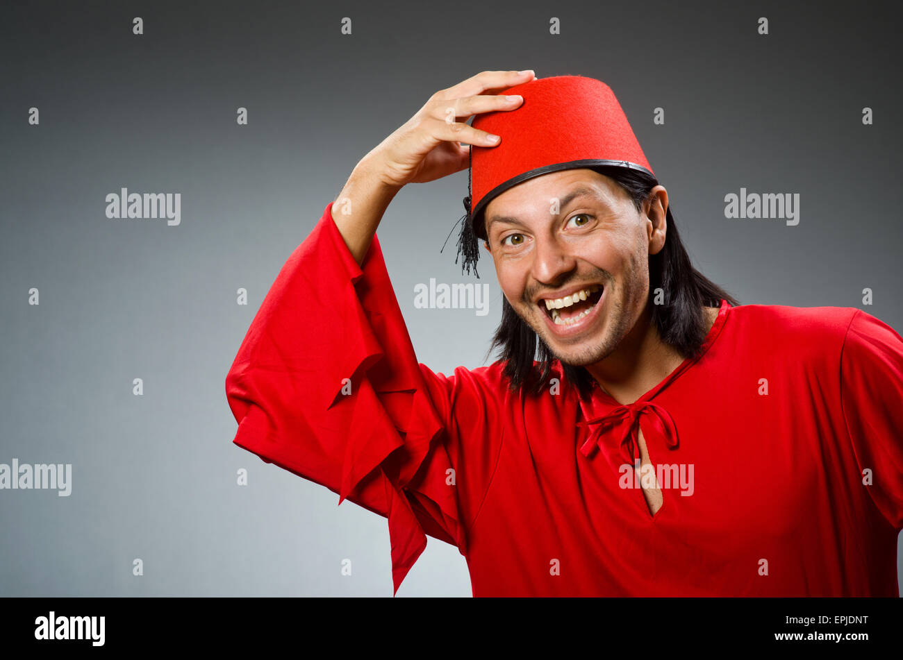 Funny man in red dress wearing fez hat Stock Photo - Alamy