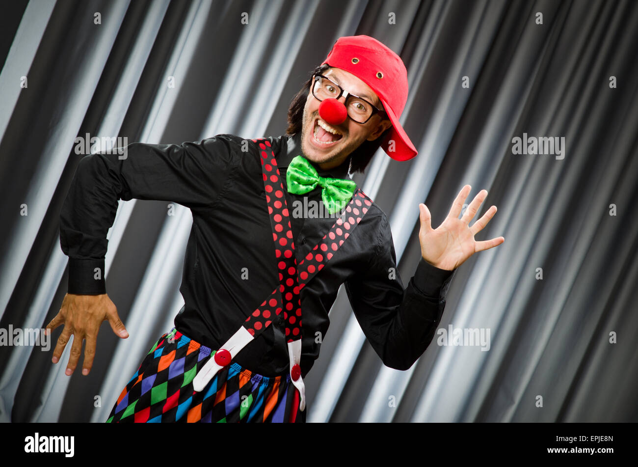 Funny clown in humorous concept against curtain Stock Photo - Alamy