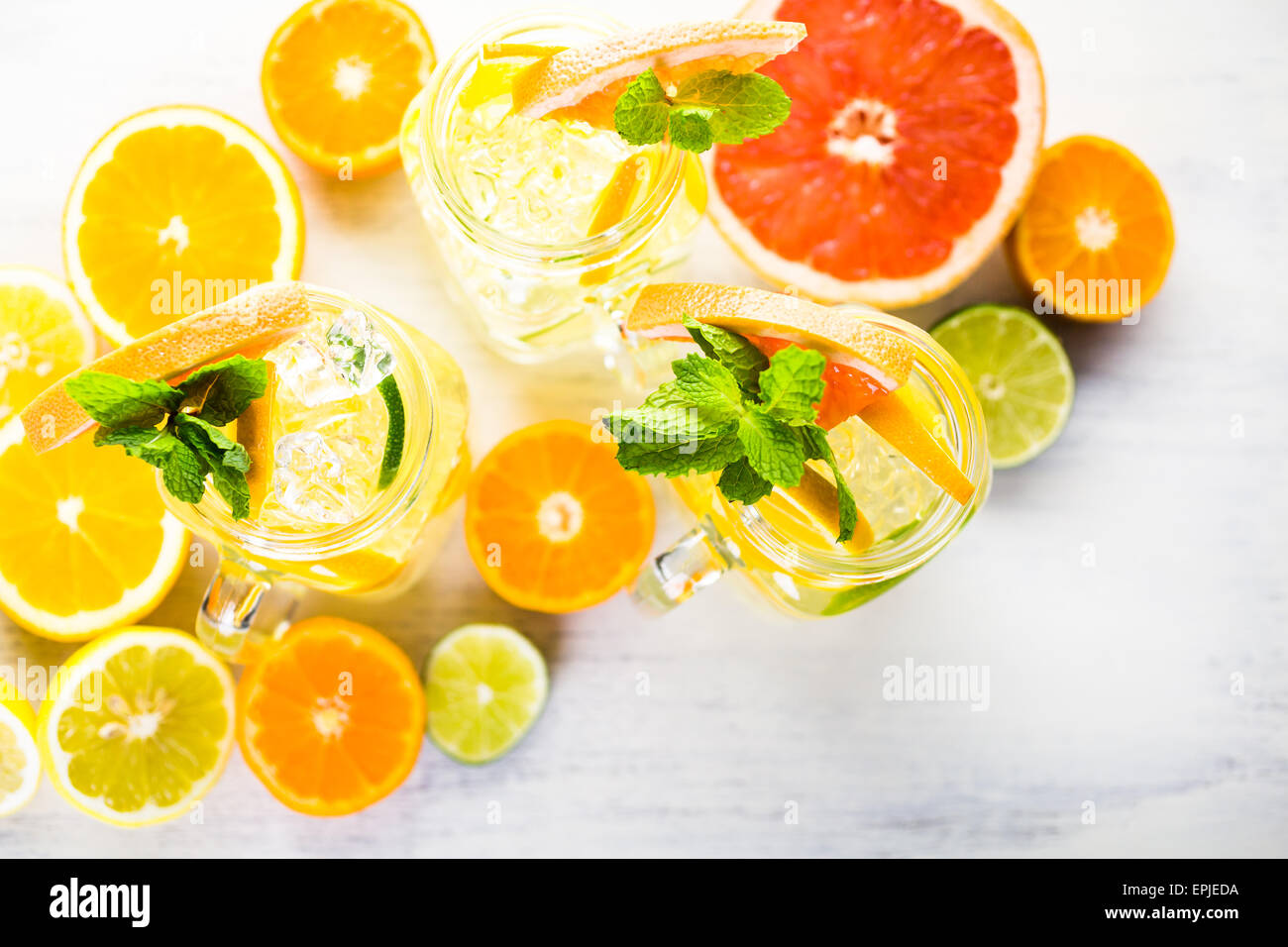 Infused water with fresh citrus fruits and ice Stock Photo - Alamy