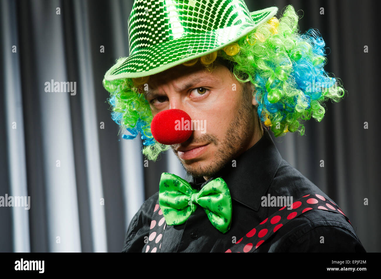 Funny clown in humorous concept against curtain Stock Photo - Alamy