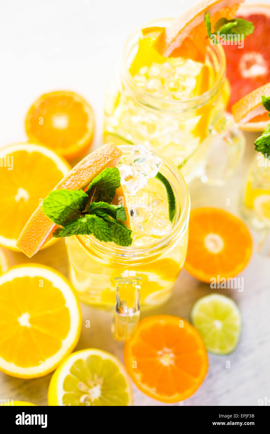 Infused water with fresh citrus fruits and ice Stock Photo - Alamy