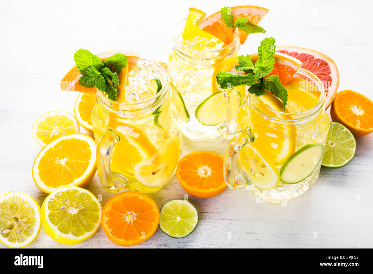 Infused water with fresh citrus fruits and ice Stock Photo - Alamy