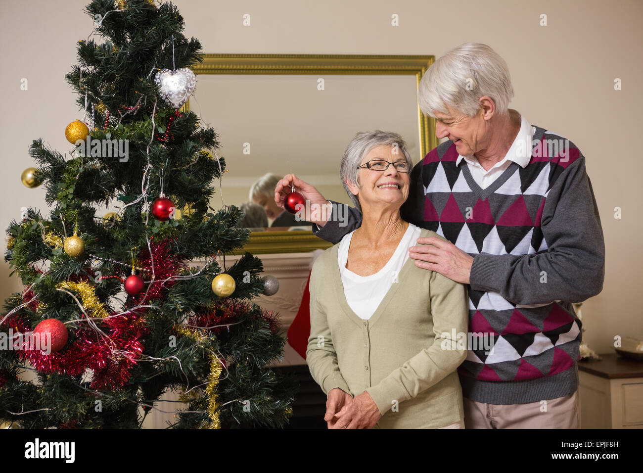Senior couple decorating their christmas tree Stock Photo - Alamy