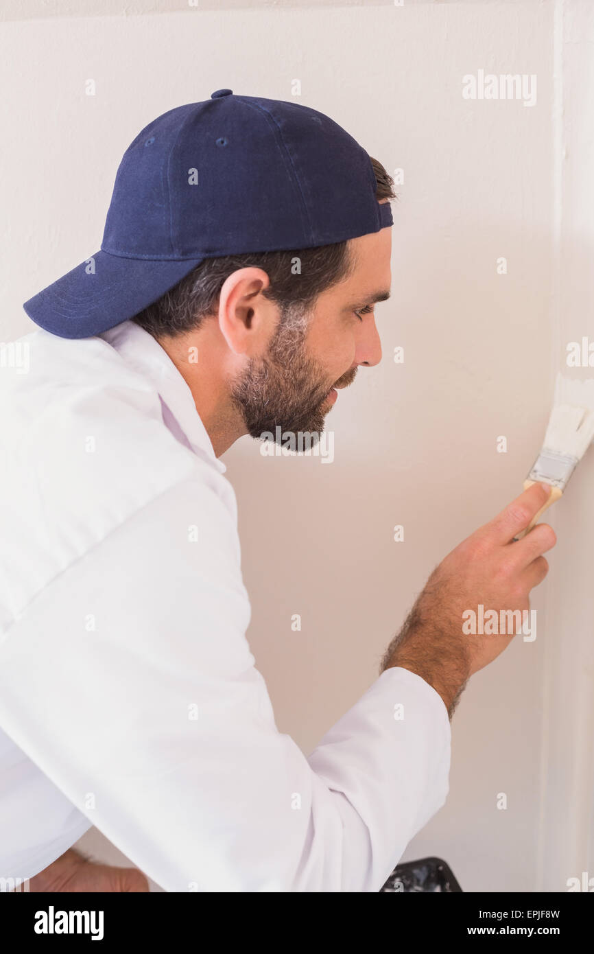 Painter painting the walls white Stock Photo - Alamy