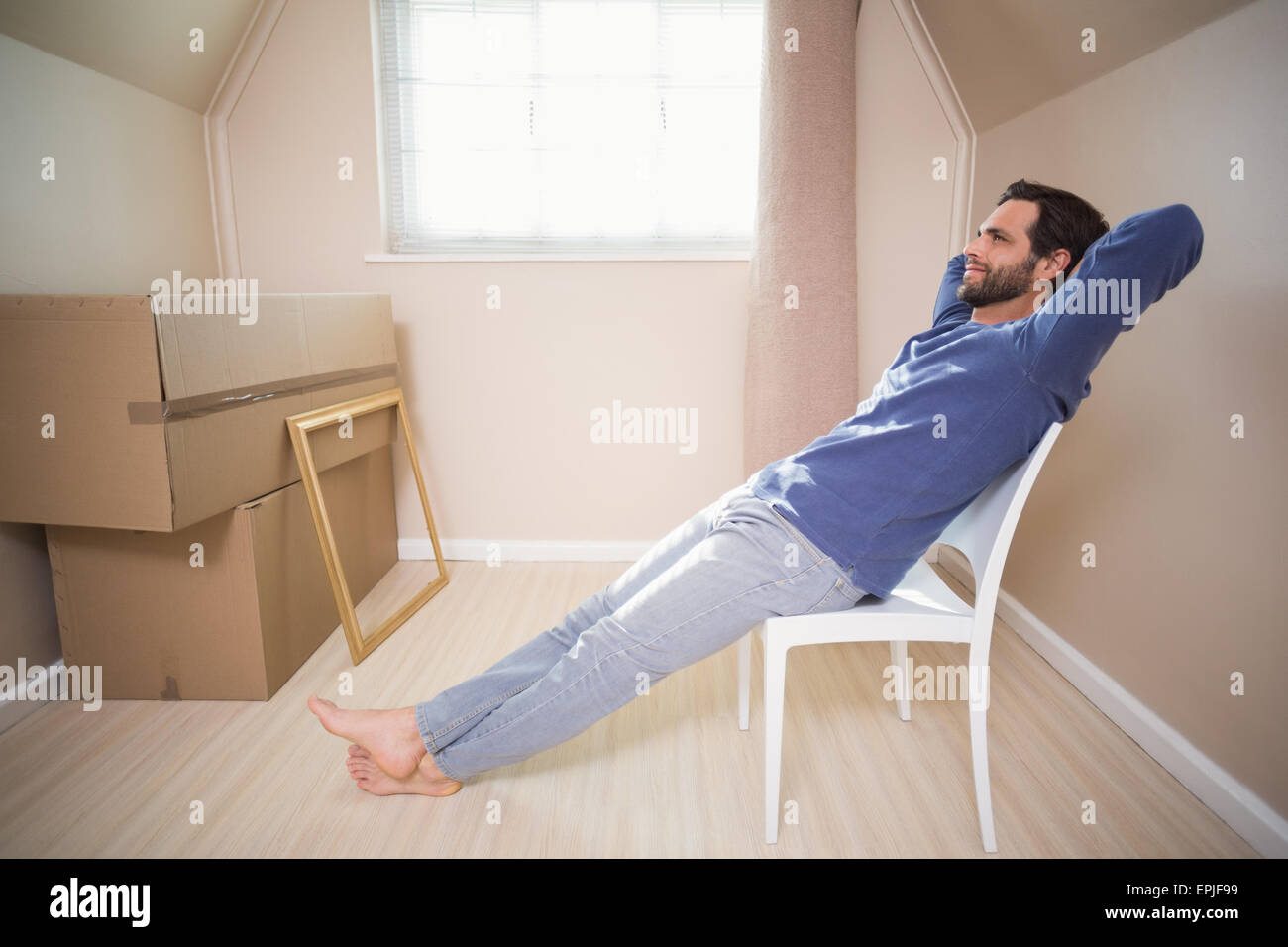 Happy man sitting back after moving in Stock Photo - Alamy