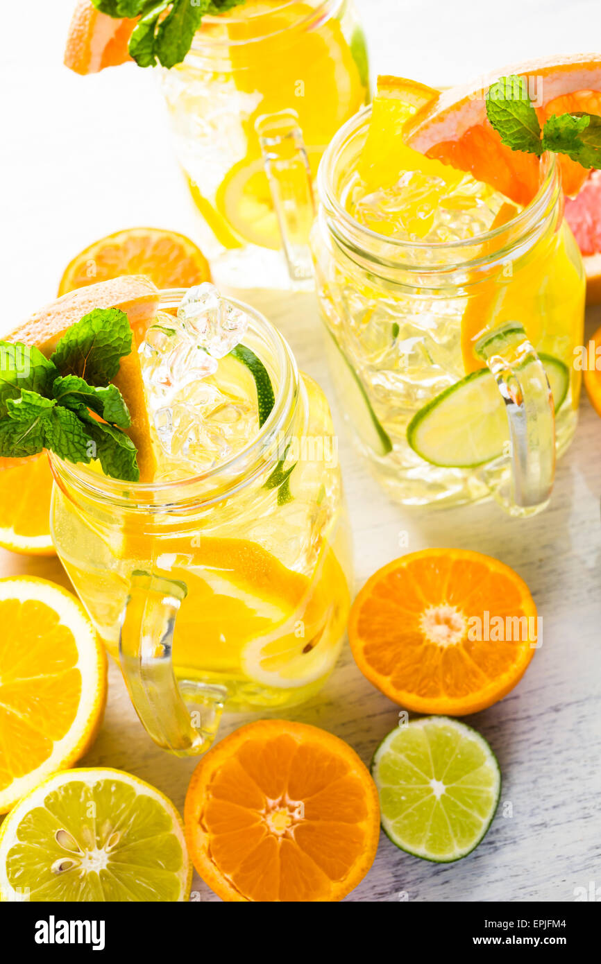 Infused water with fresh citrus fruits and ice Stock Photo - Alamy