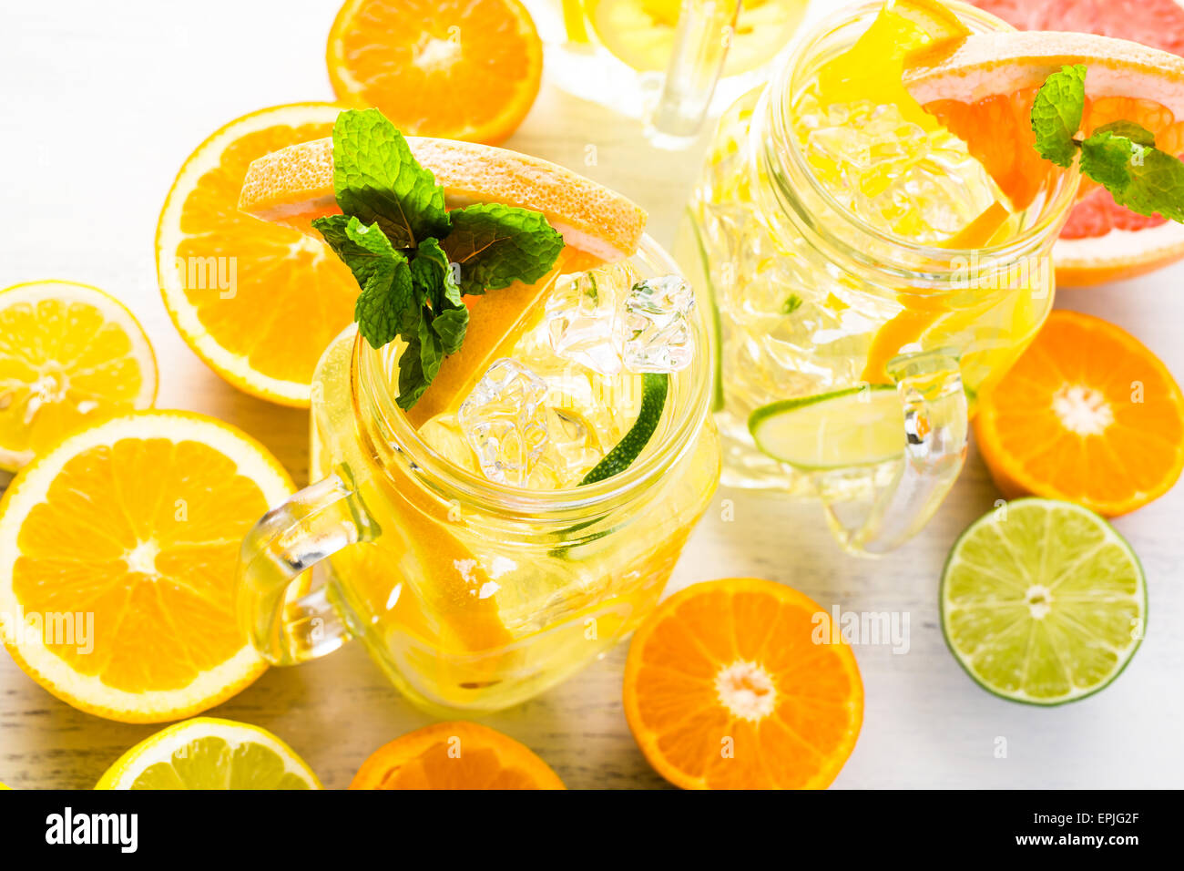 Infused water with fresh citrus fruits and ice Stock Photo - Alamy