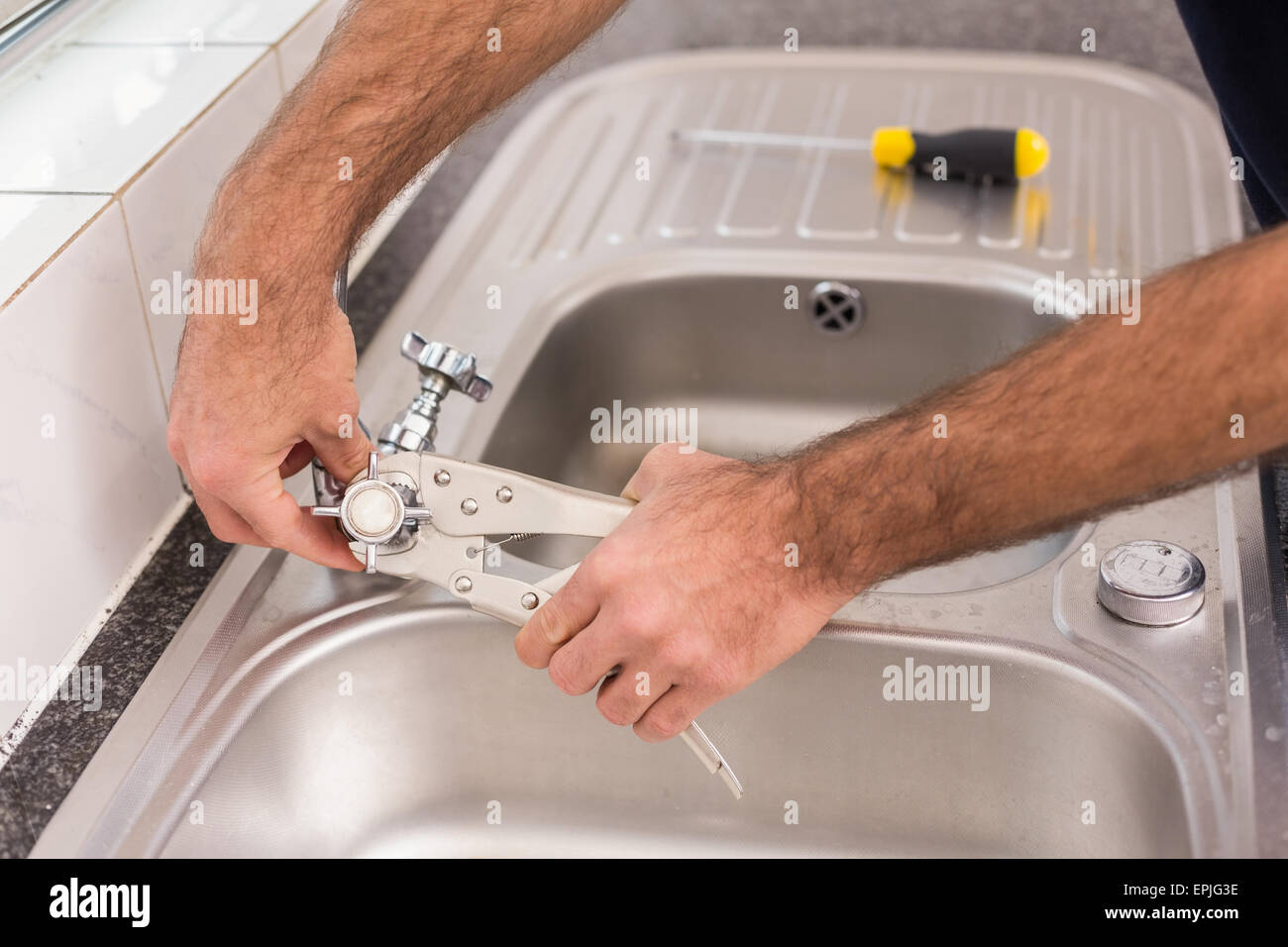 Man fixing tap with pliers Stock Photo - Alamy