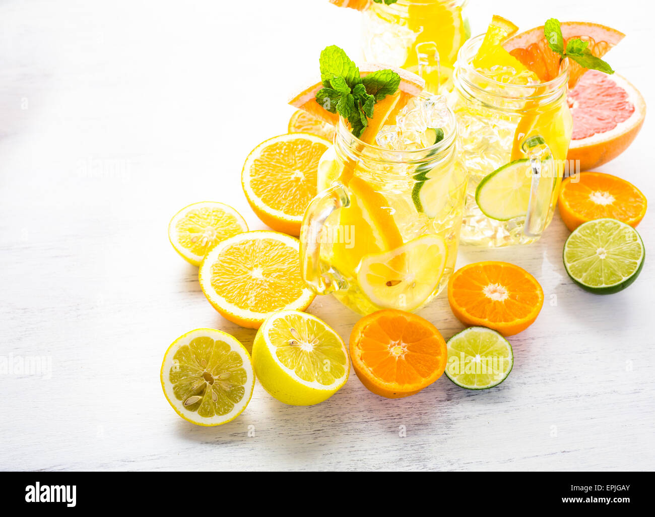 Infused water with fresh citrus fruits and ice Stock Photo - Alamy