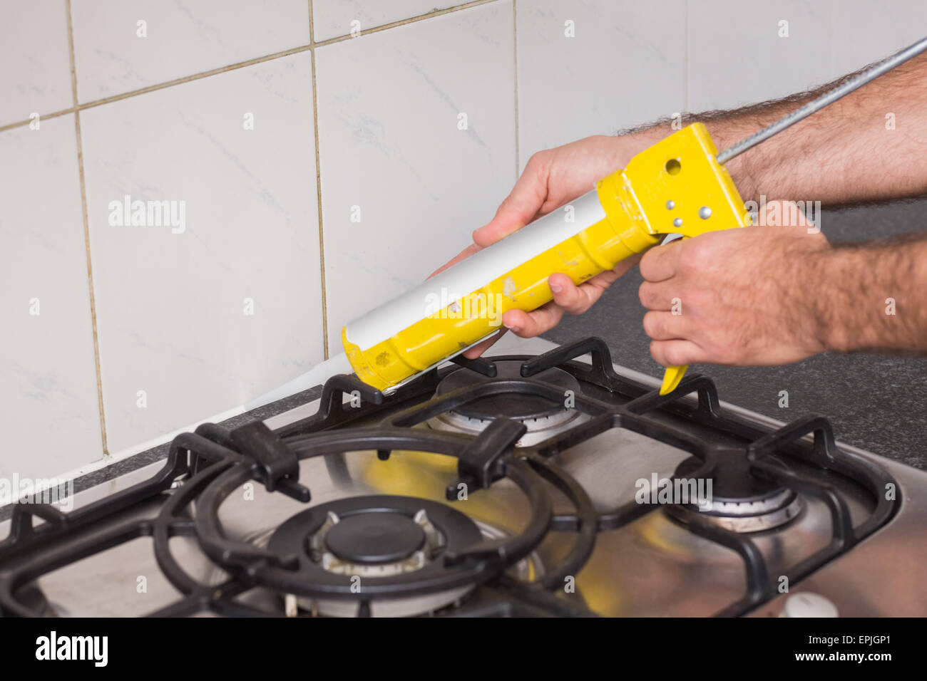 Plumber putting filling in between tiles Stock Photo - Alamy
