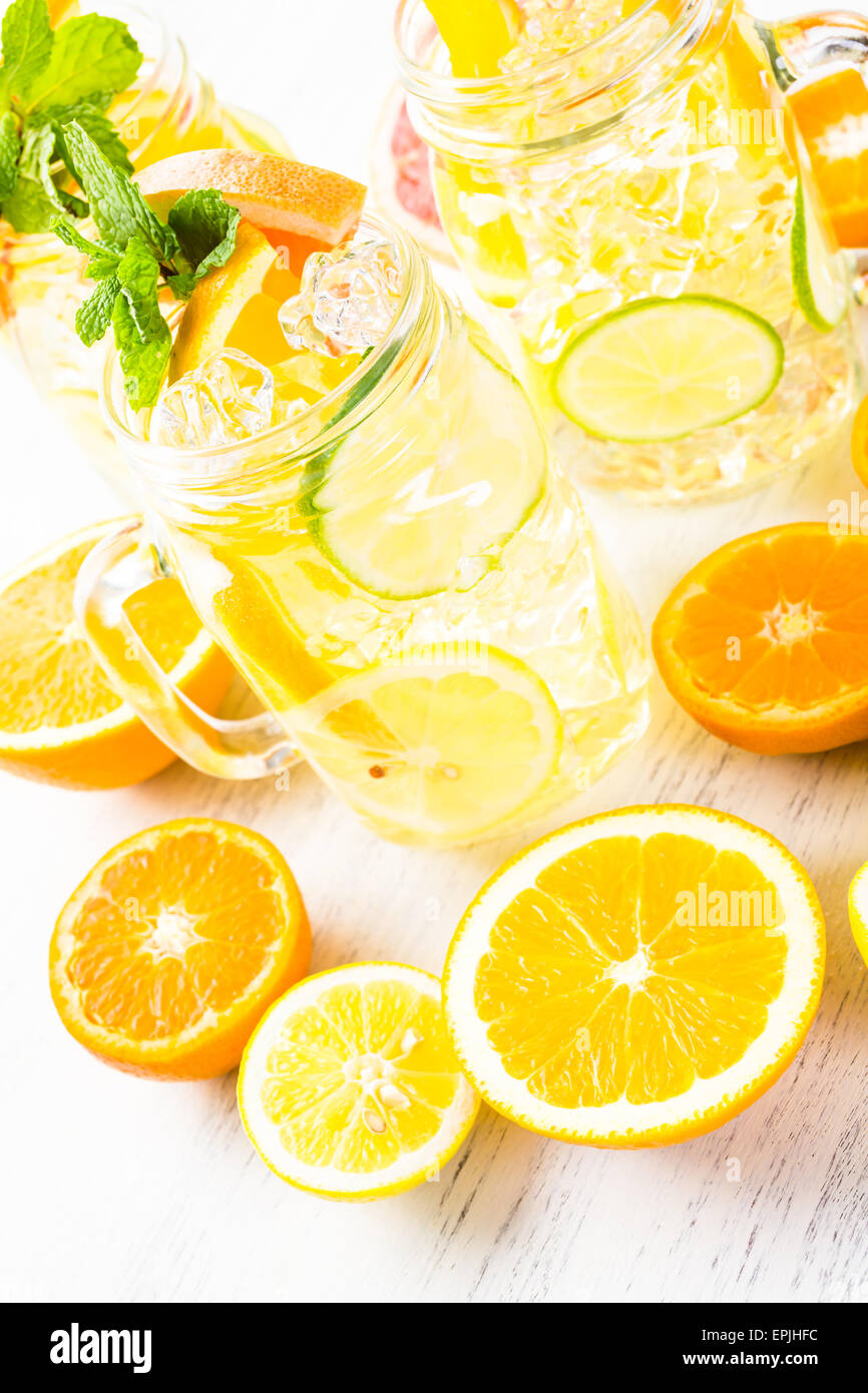 Infused water with fresh citrus fruits and ice Stock Photo - Alamy
