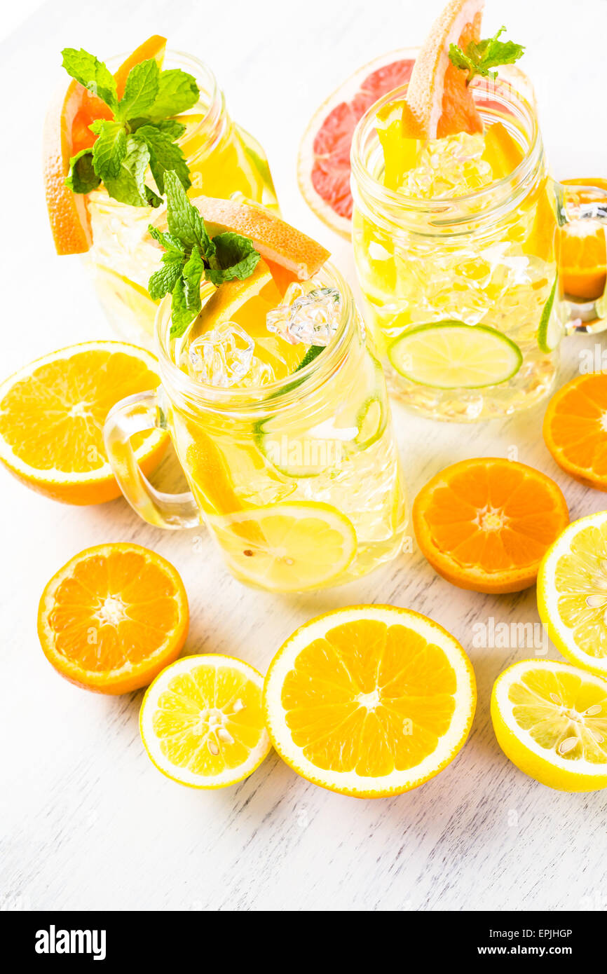Infused water with fresh citrus fruits and ice Stock Photo - Alamy