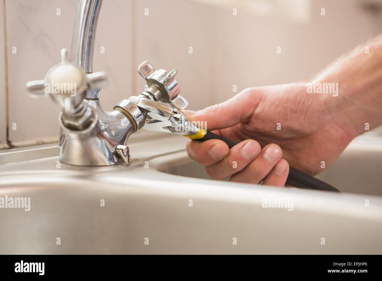Man fixing tap with pliers Stock Photo - Alamy