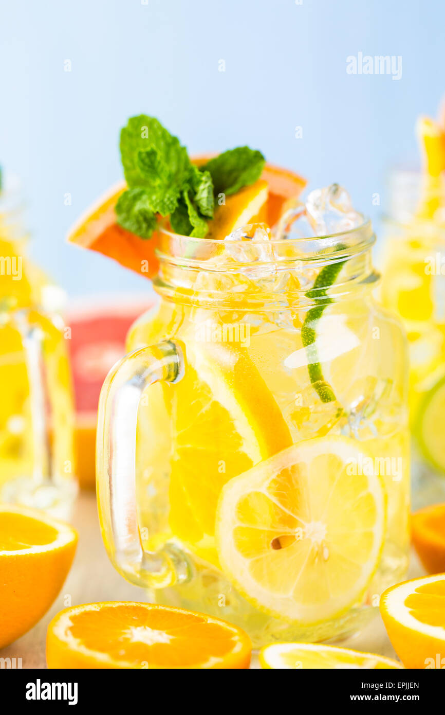 Infused water with fresh citrus fruits and ice Stock Photo - Alamy
