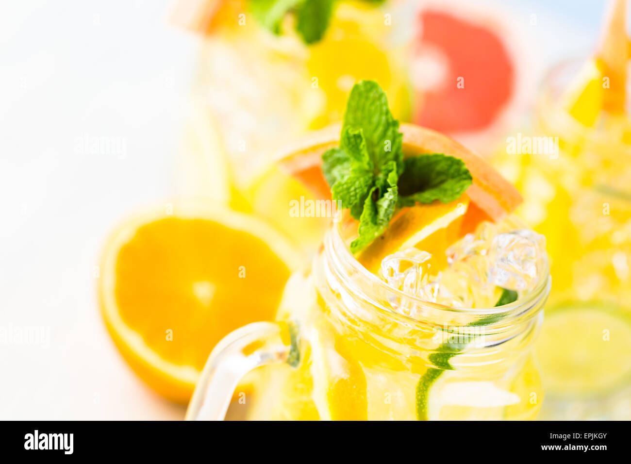 Infused water with fresh citrus fruits and ice Stock Photo - Alamy
