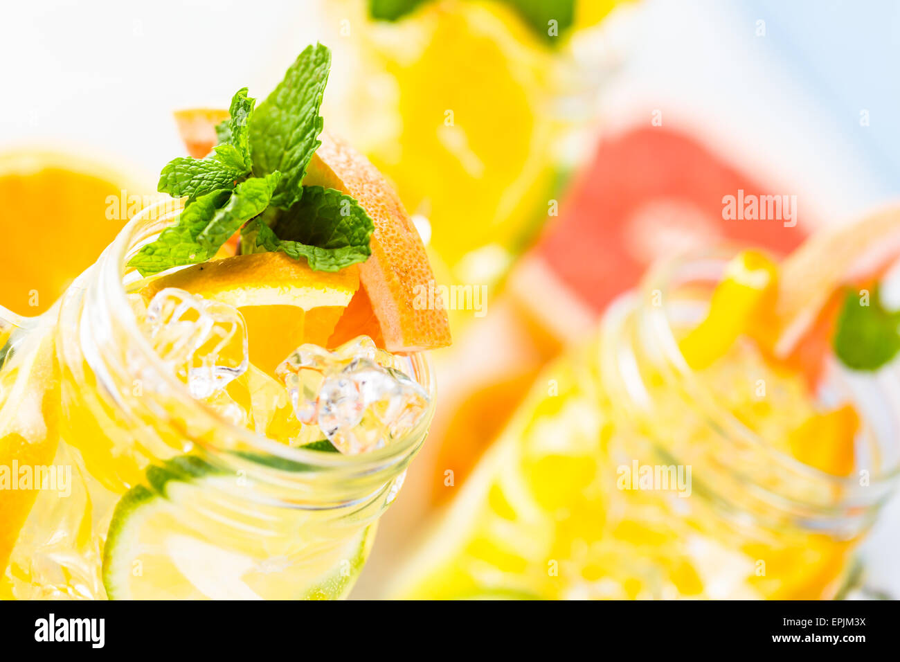 Infused water with fresh citrus fruits and ice Stock Photo - Alamy