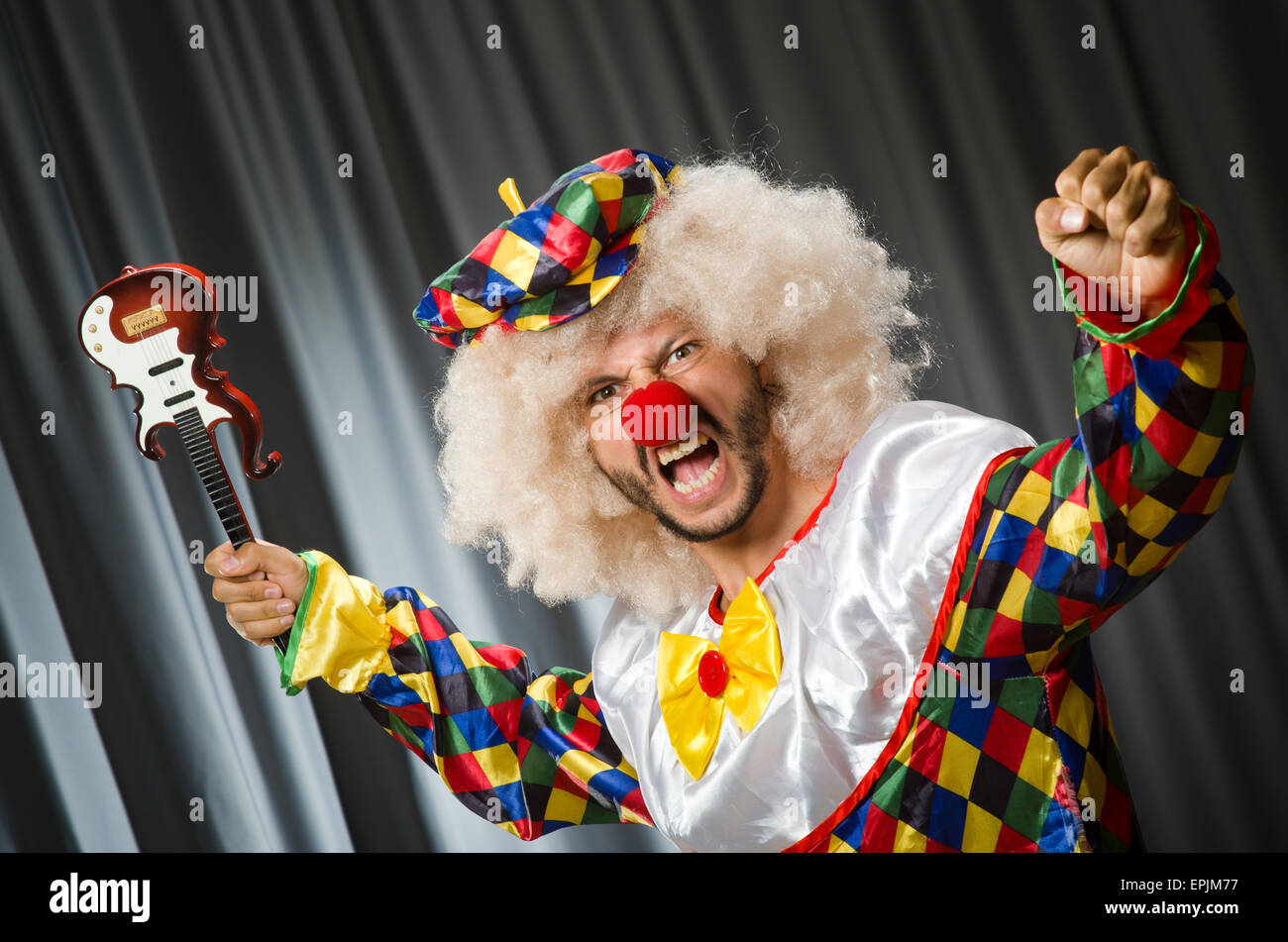 Angry clown with guitar in funny concept Stock Photo - Alamy