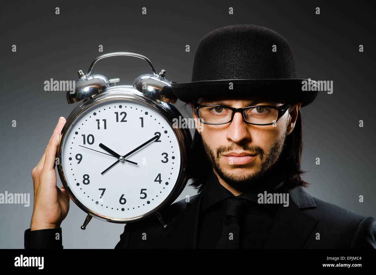 Man with clock wearing vintage hat Stock Photo - Alamy