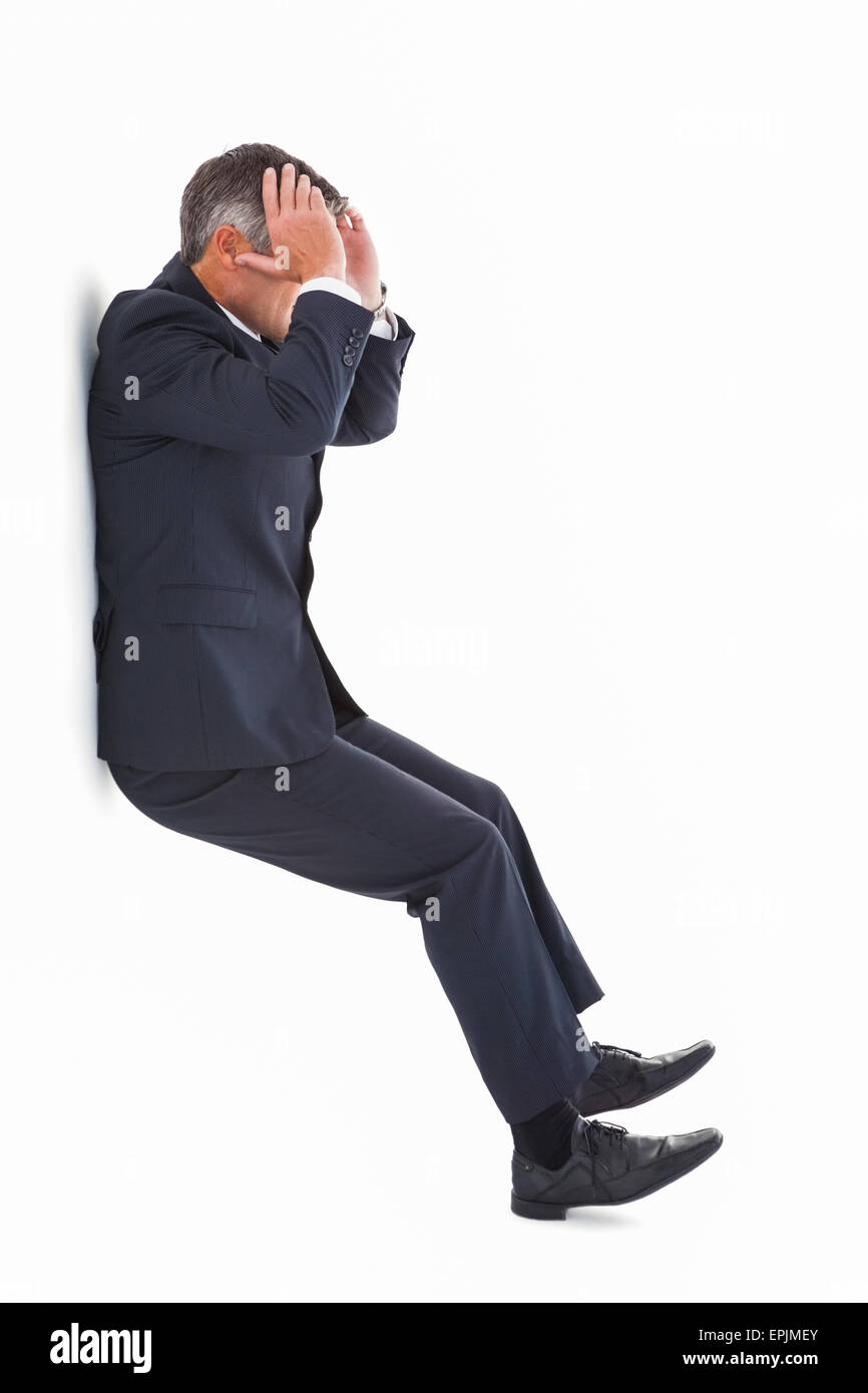 Business man leaning head to wall Cut Out Stock Images & Pictures - Alamy