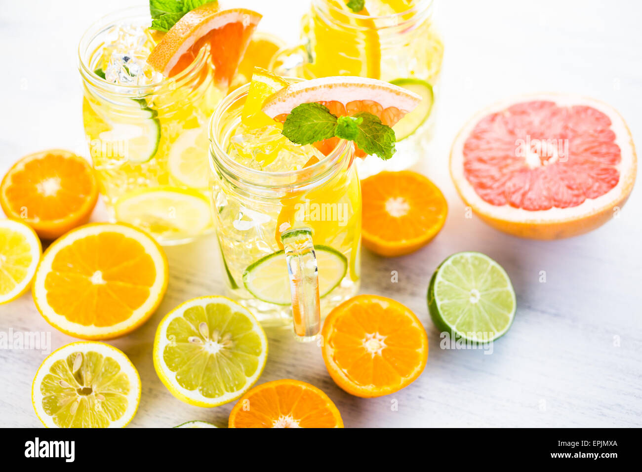 Infused water with fresh citrus fruits and ice Stock Photo - Alamy