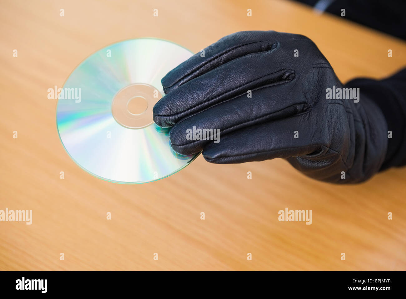 Hacker holding a cd rom Stock Photo - Alamy
