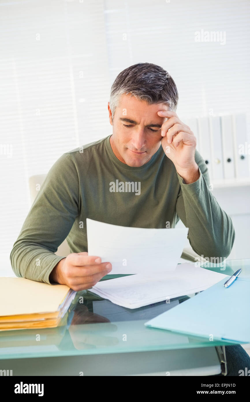 Smiling man with grey hair reading paper Stock Photo - Alamy