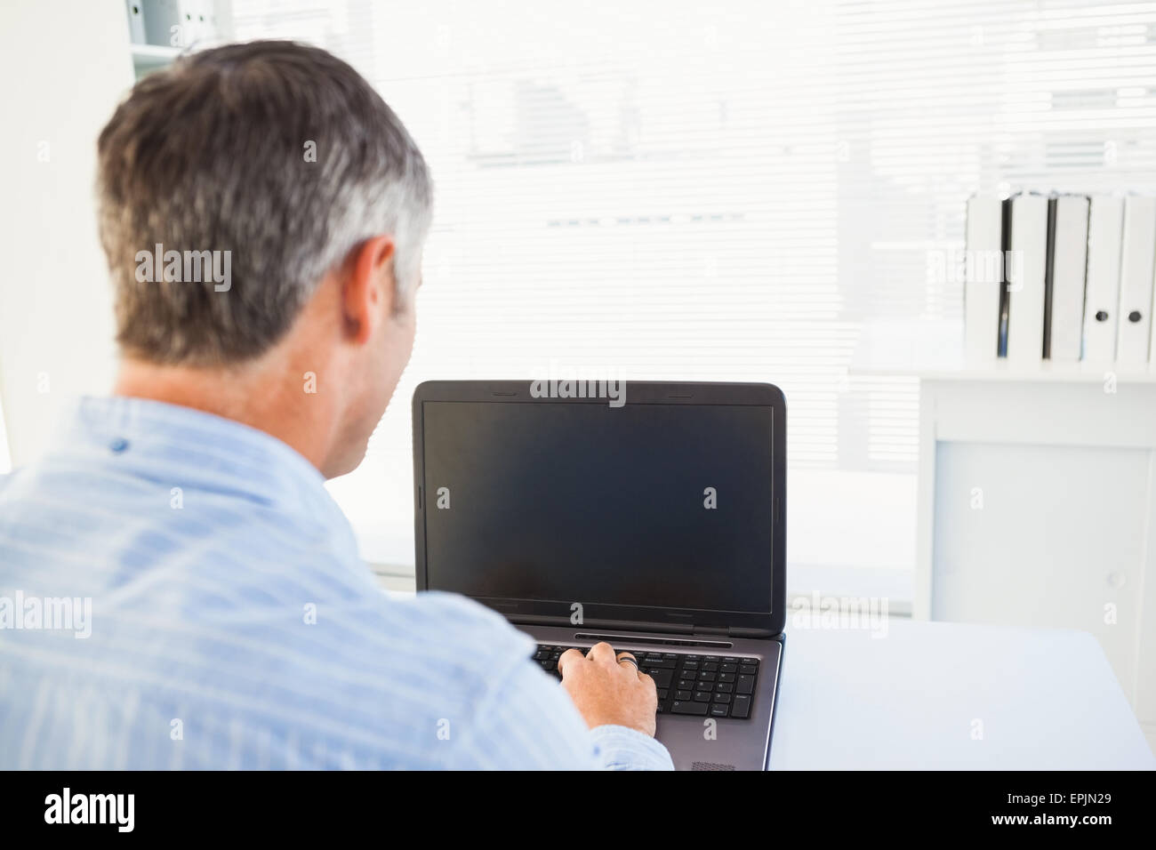 Man with grey hair using his laptop Stock Photo - Alamy