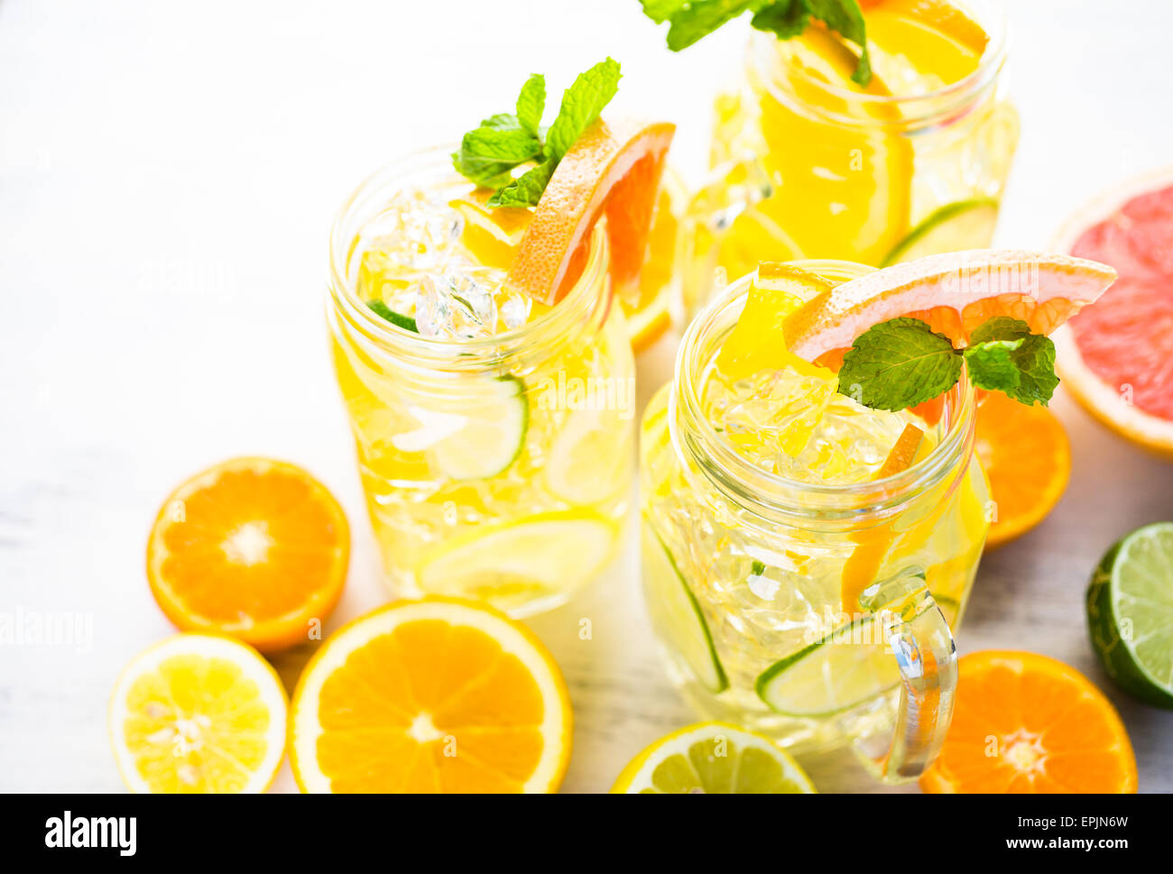 Infused water with fresh citrus fruits and ice Stock Photo - Alamy