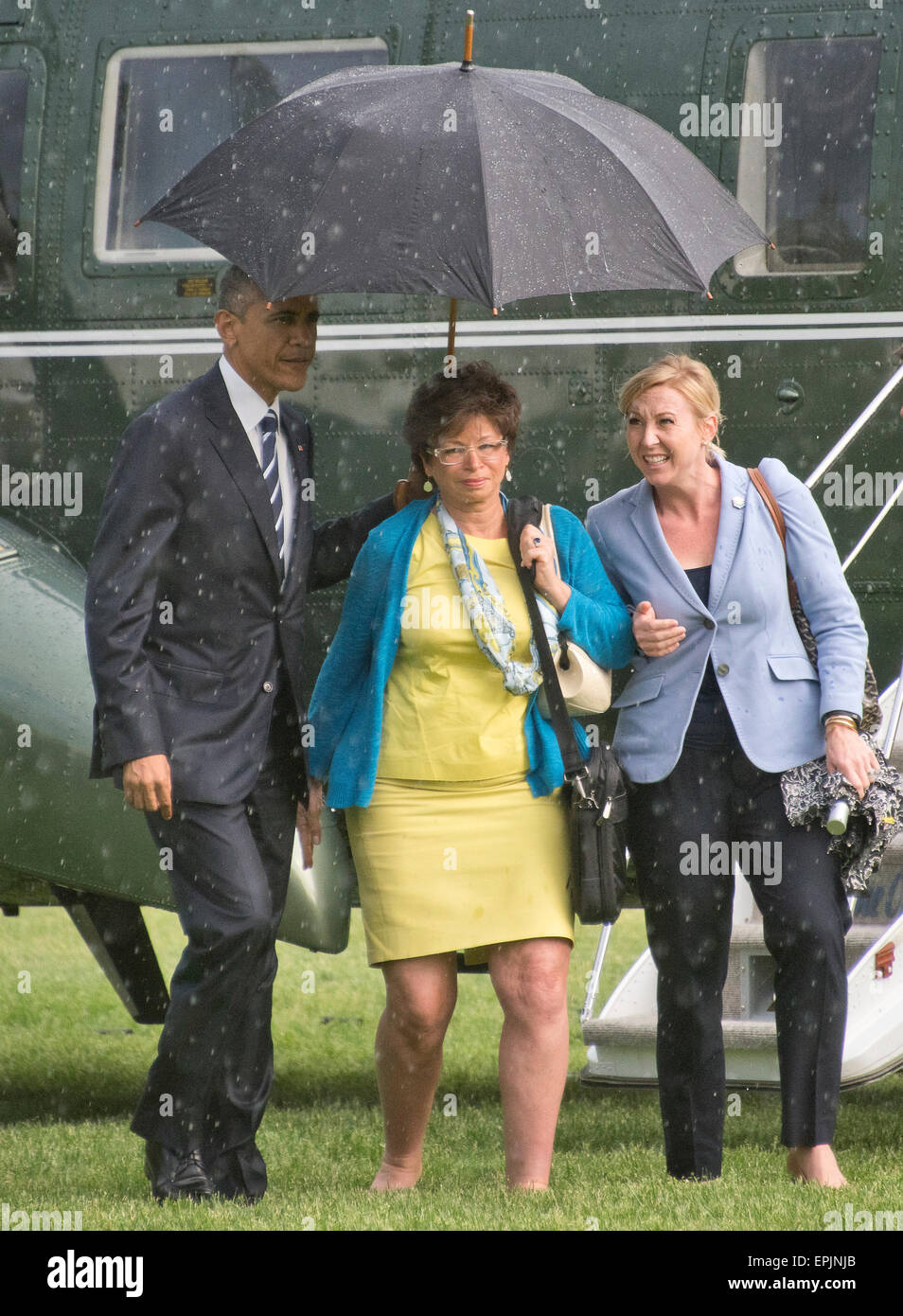 United States President Barack Obama, left, holds the umbrella for ...