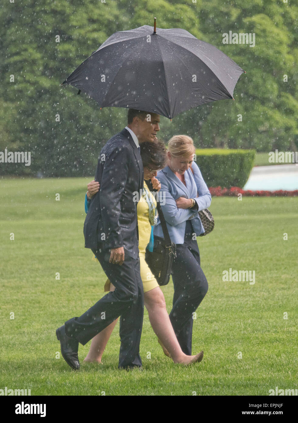 United States President Barack Obama, left, holds the umbrella for ...
