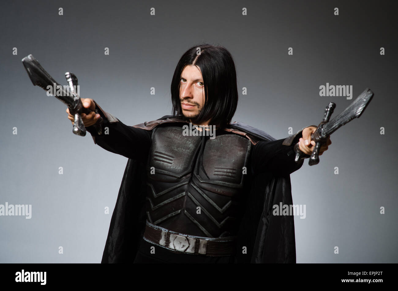 Angry knight with sword against dark background Stock Photo - Alamy