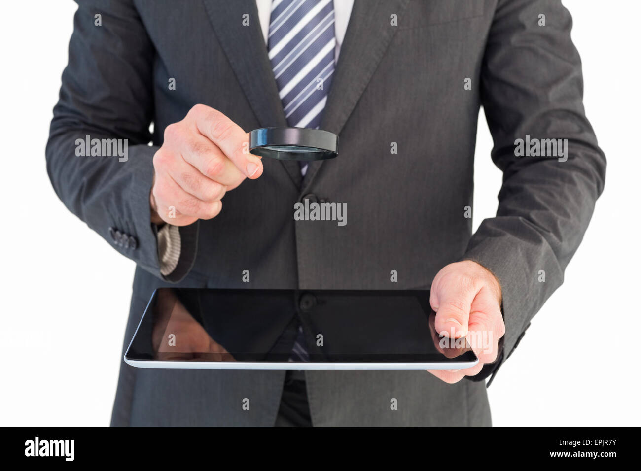 Businessman looking at tablet with magnifying glass Stock Photo - Alamy