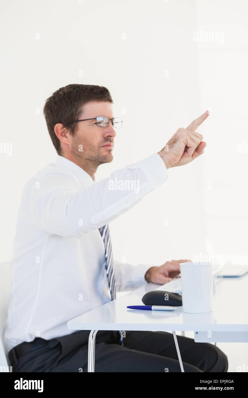 Businessman pointing at hs desk Stock Photo - Alamy