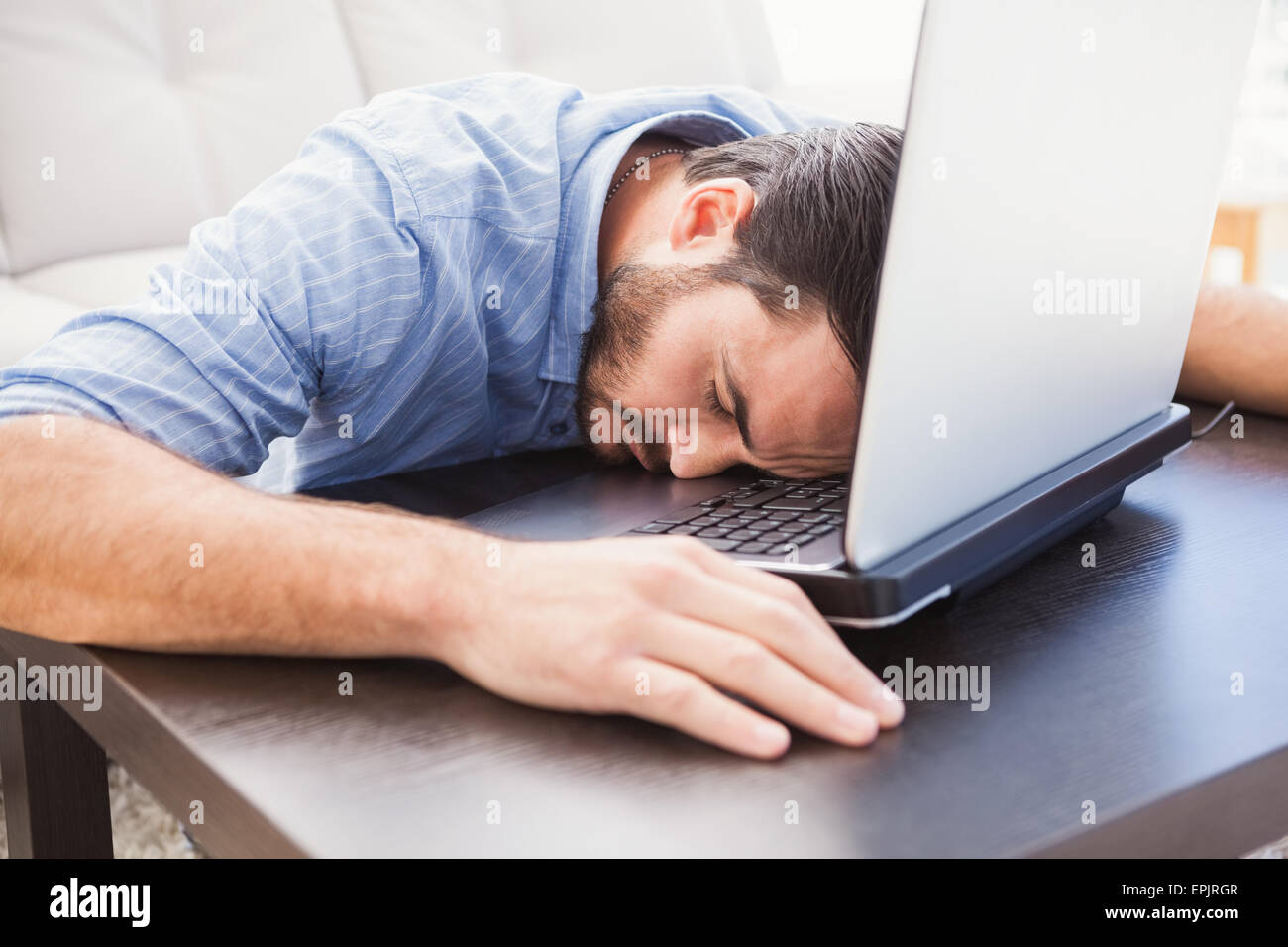 Man sleeping with head resting on laptop keyboard Stock Photo - Alamy