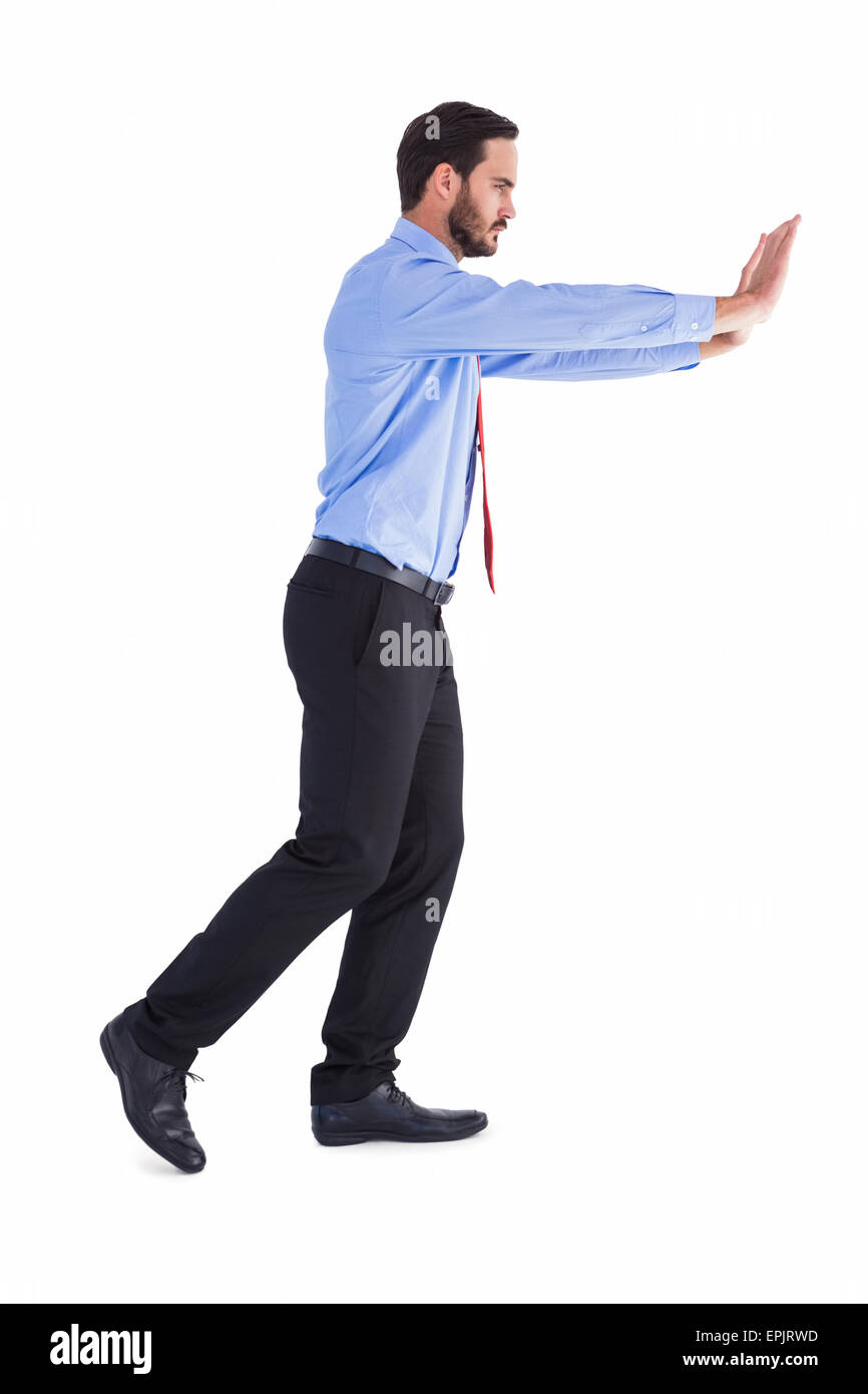 Businessman in suit pushing with effort Stock Photo - Alamy