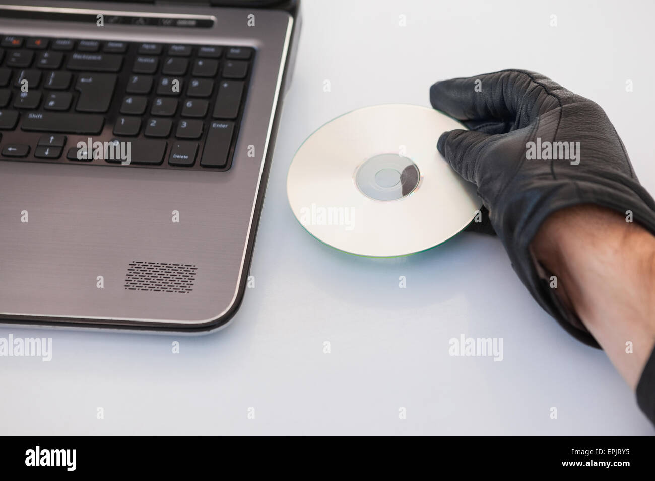 Burglar hacking and putting a cd-rom in laptop Stock Photo - Alamy