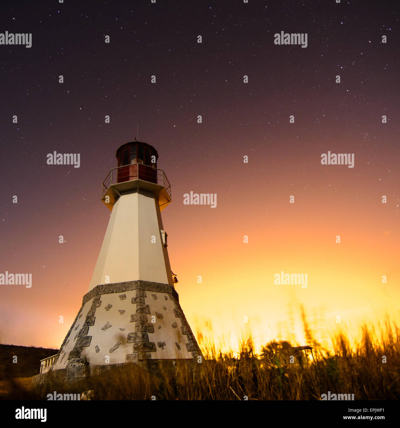 lighthouse with beam to night sky at background stars trails Stock ...