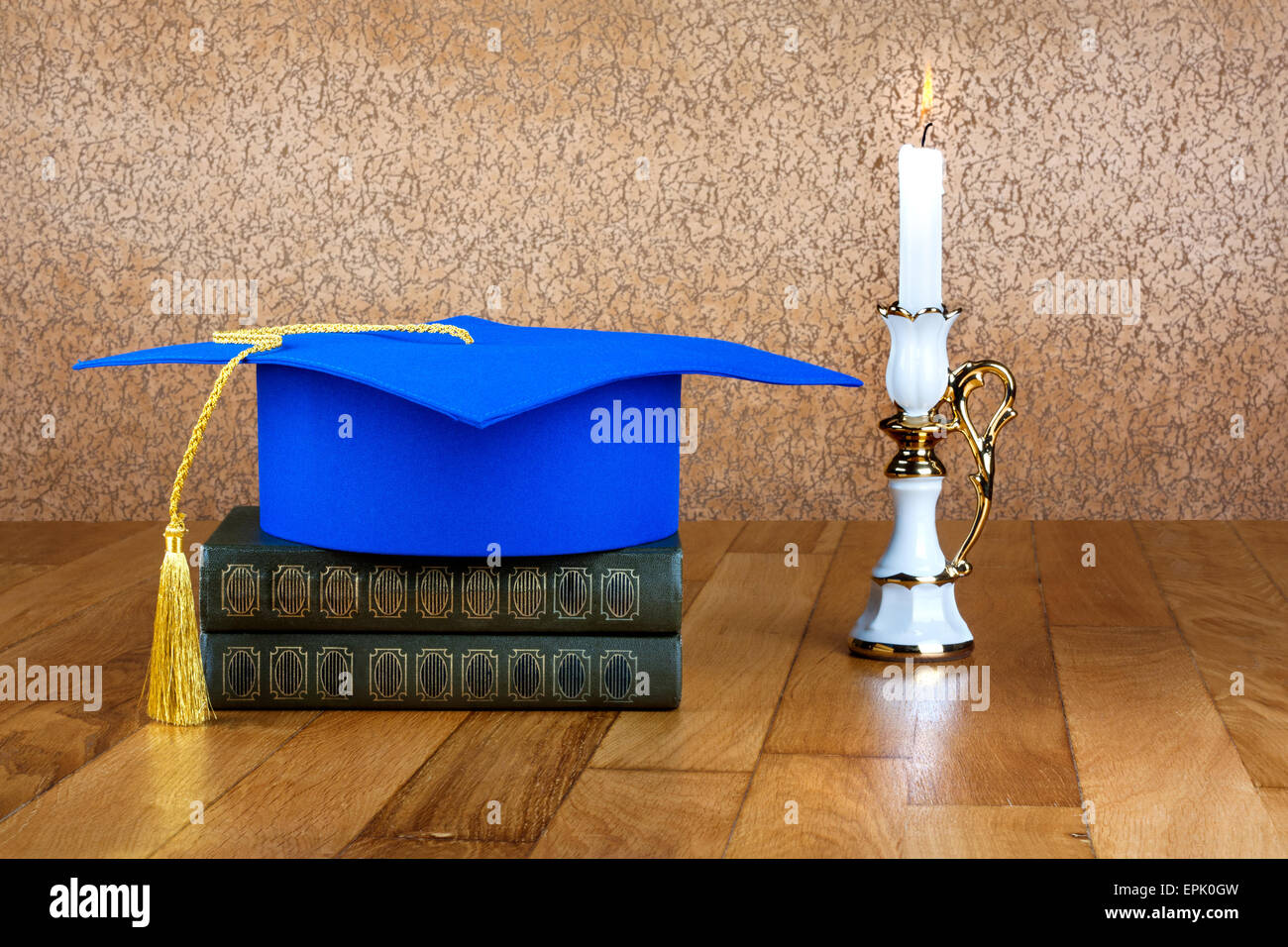 Graduation mortarboard on top of stack of books on abstract background ...