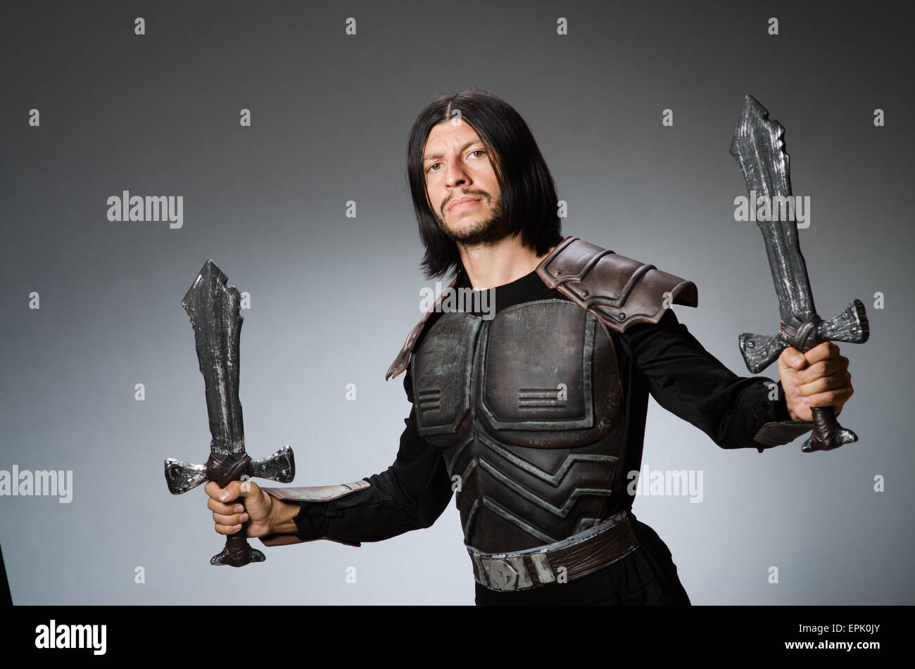 Angry knight with sword against dark background Stock Photo - Alamy