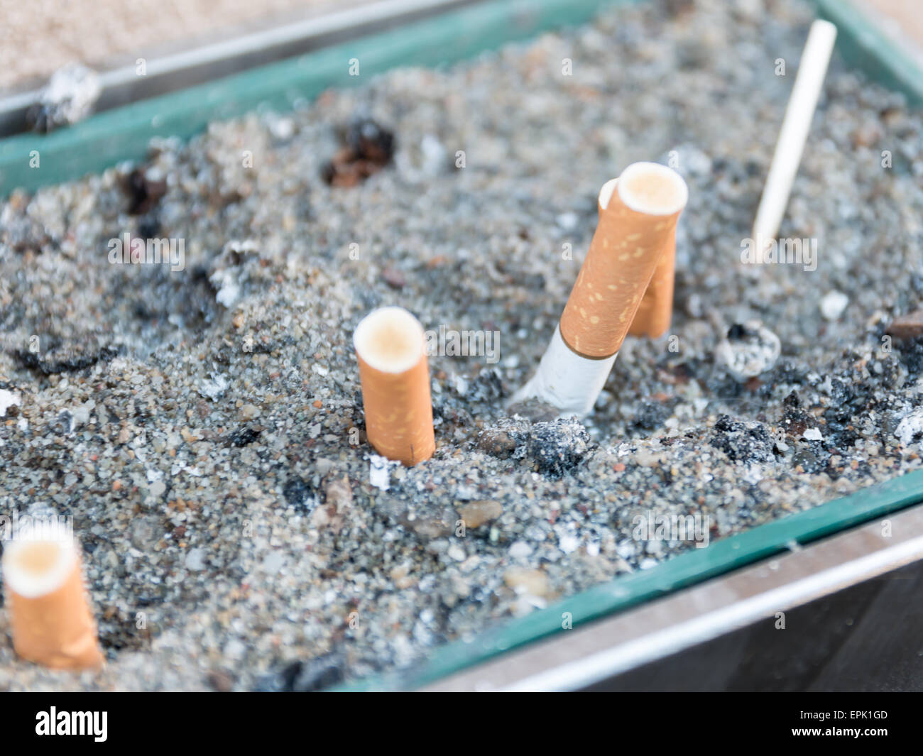 cigarettes butt in sand ashtray; sand litter Stock Photo - Alamy