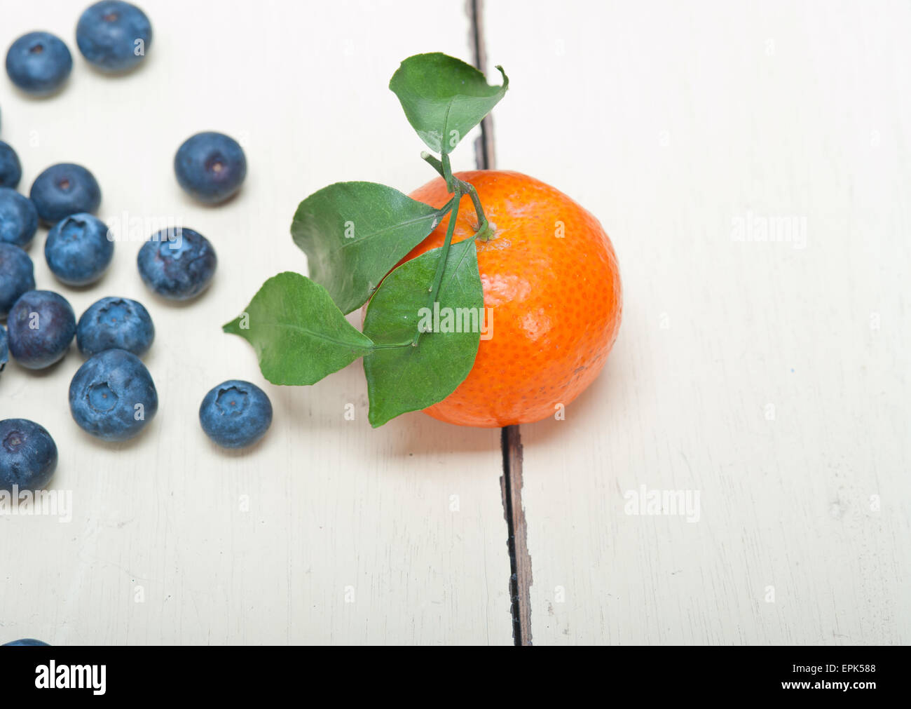 tangerine and blueberry on white table Stock Photo - Alamy