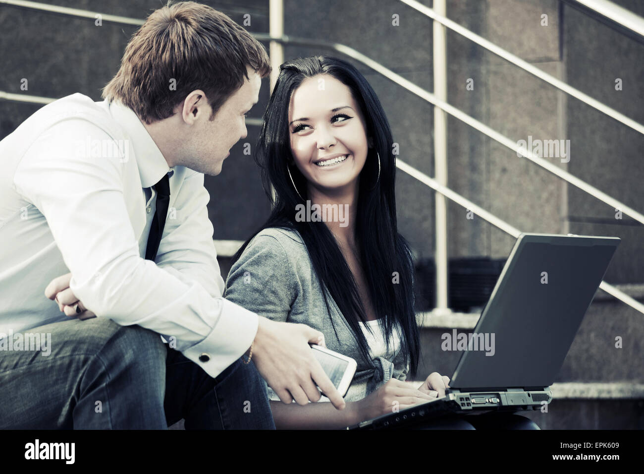 Young business couple using laptop outdoor Stock Photo - Alamy
