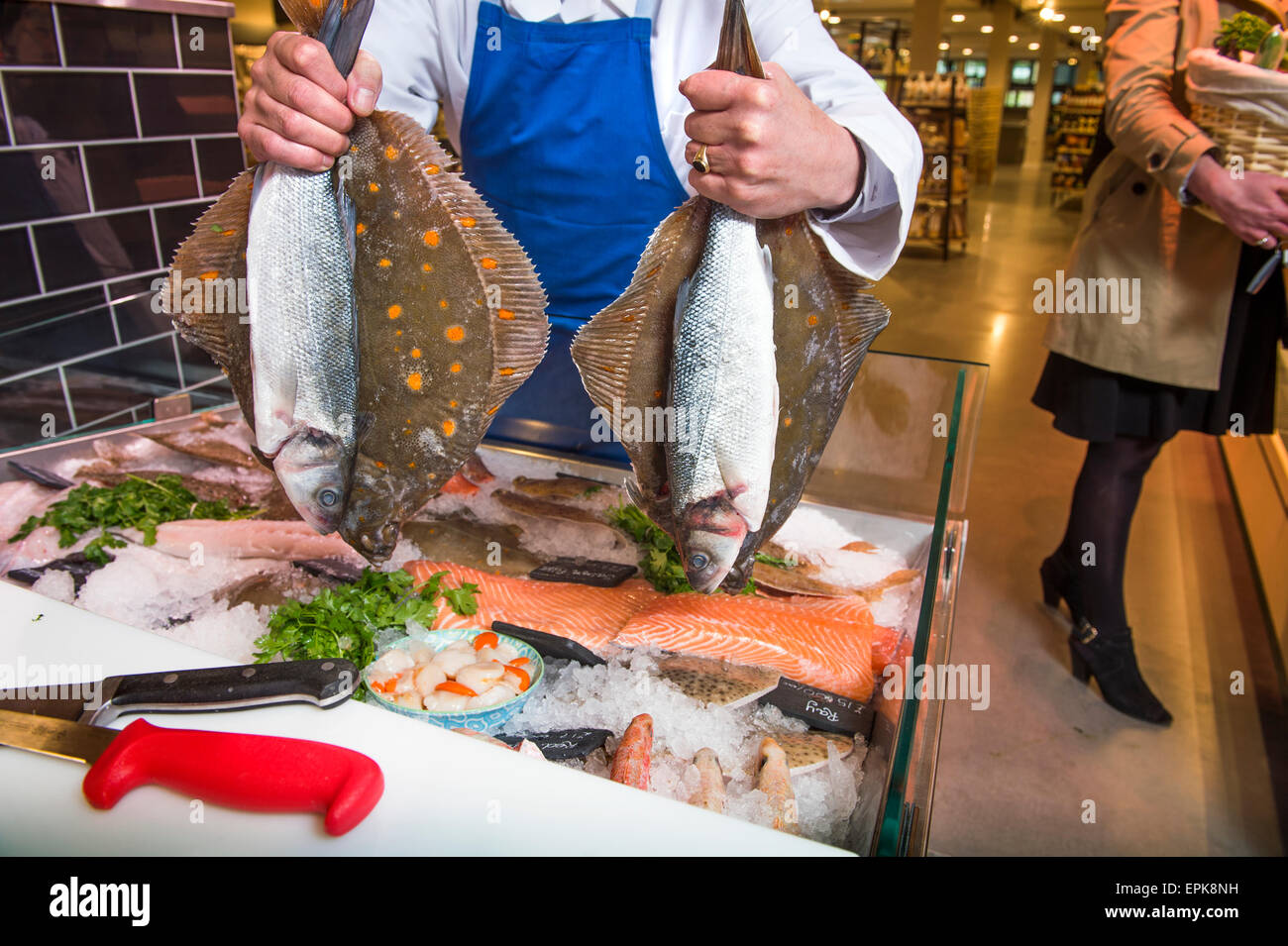 A fishmonger at his counter with Plaice and Sea Bass UK Stock Photo - Alamy
