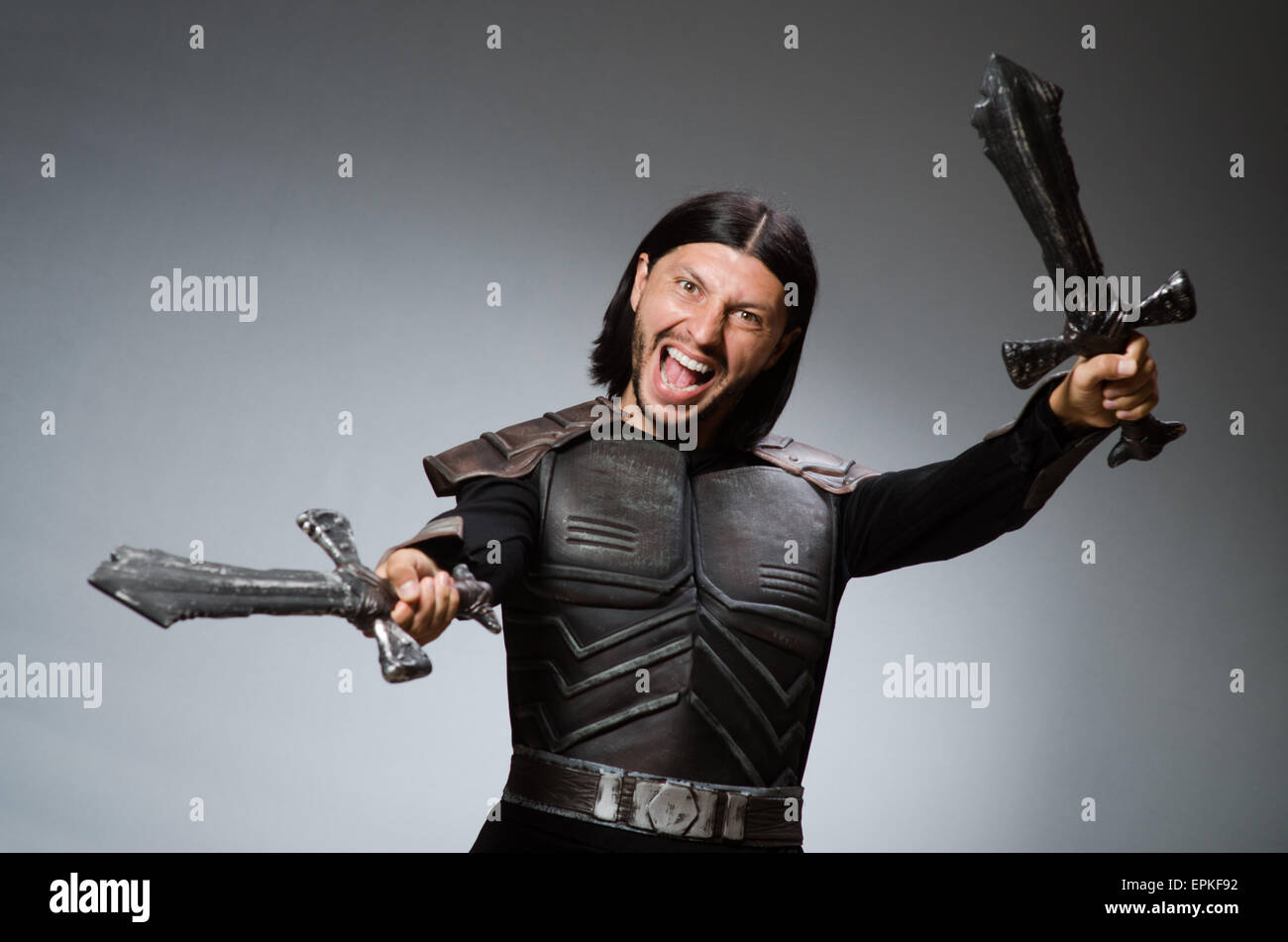 Angry knight with sword against dark background Stock Photo - Alamy
